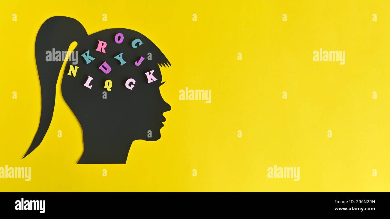 Silhouette of a woman's head with letters in the brain. on a yellow ...