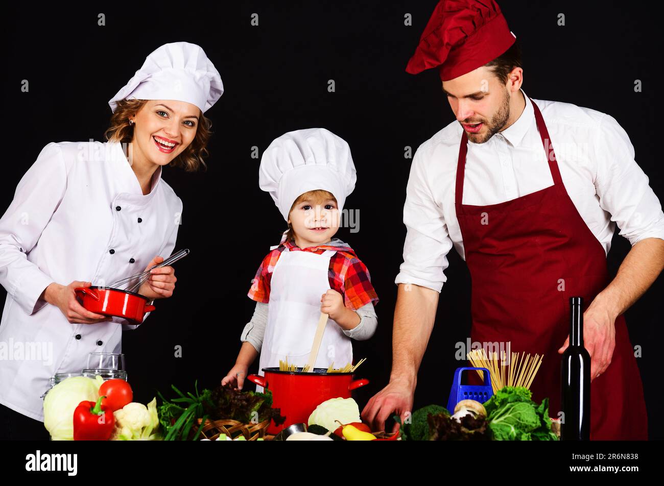 Mother and father teaching son to cook. Happy family in chef uniform ...