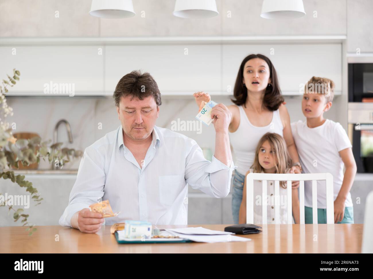 On kitchen table, father of family laid out financial documents and ...