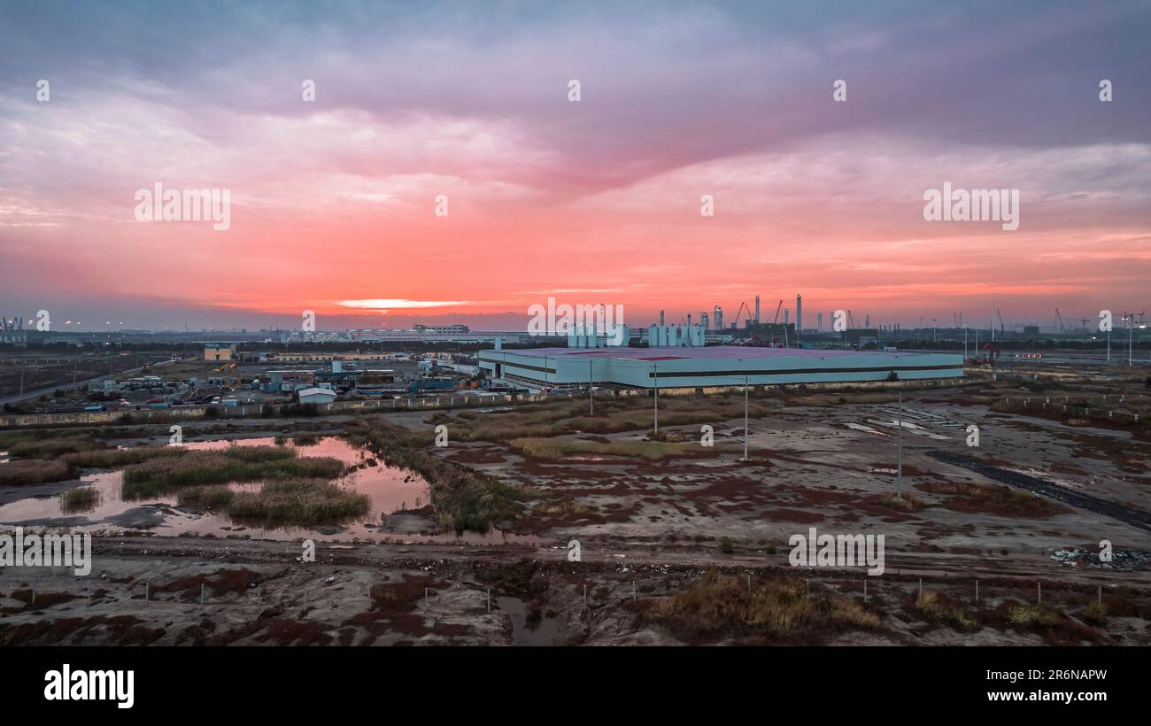 A beautiful sunrise rises over a large factory with tall windows Stock ...
