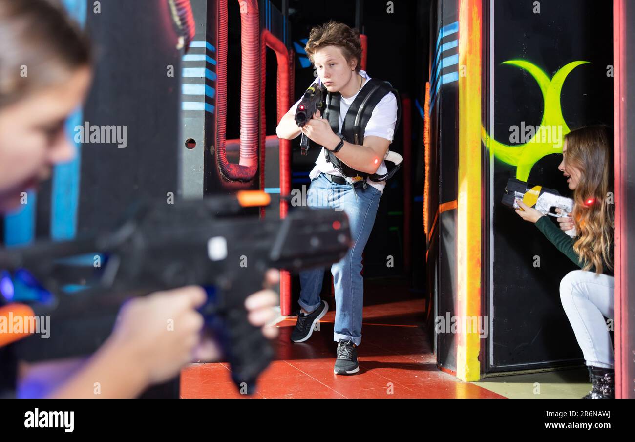 Boy running and dodging while playing lasertag Stock Photo - Alamy