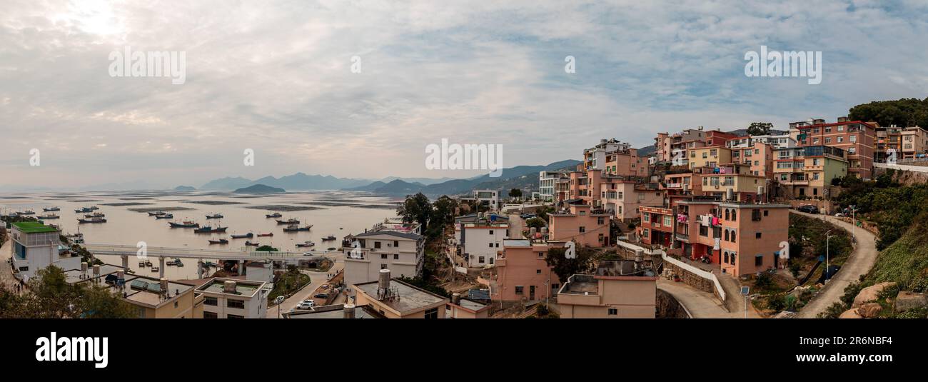 A panoramic view of a seaside town with waterfront buildings and boats ...