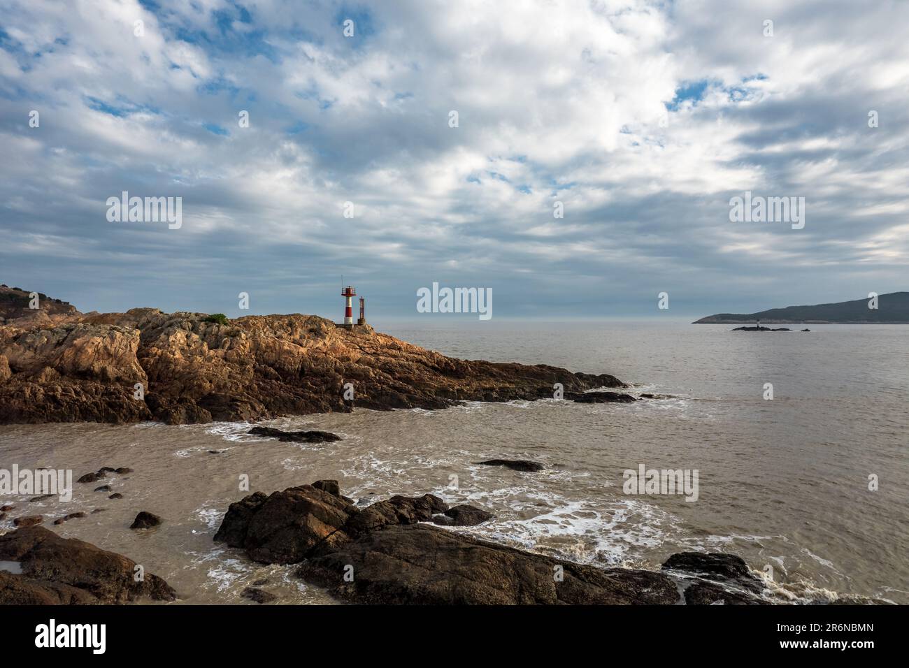 A lighthouse atop a rocky cliff overlooking the vast expanse of the ...