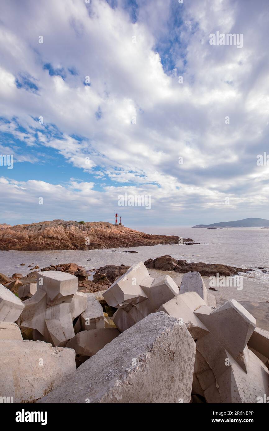 A lighthouse atop a rocky cliff overlooking the vast expanse of the ...