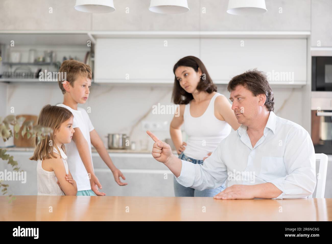 Angry parents scolding two children standing in front of them Stock ...