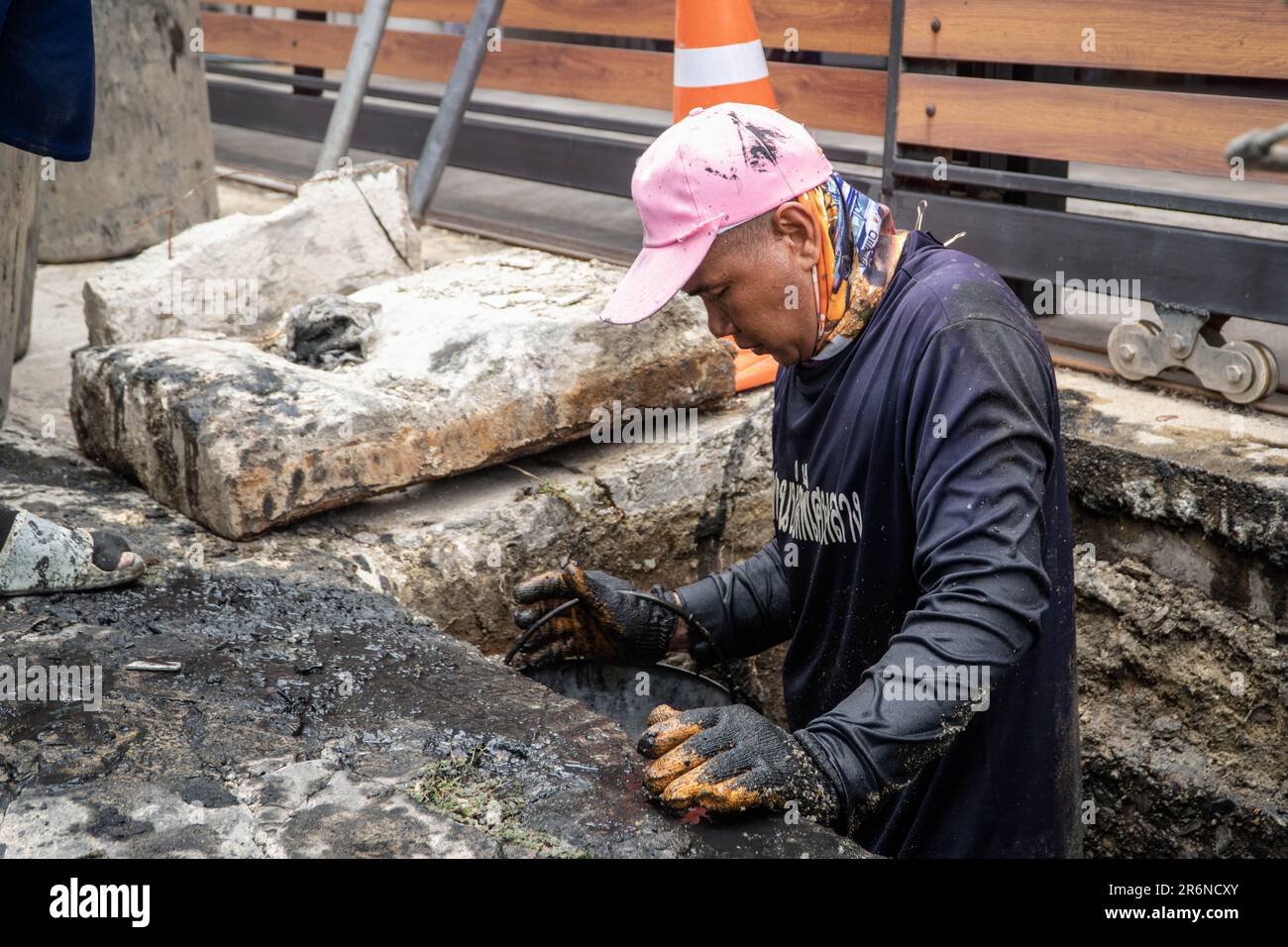 A Thai inmate seen working inside a public sewer to scrape away the ...
