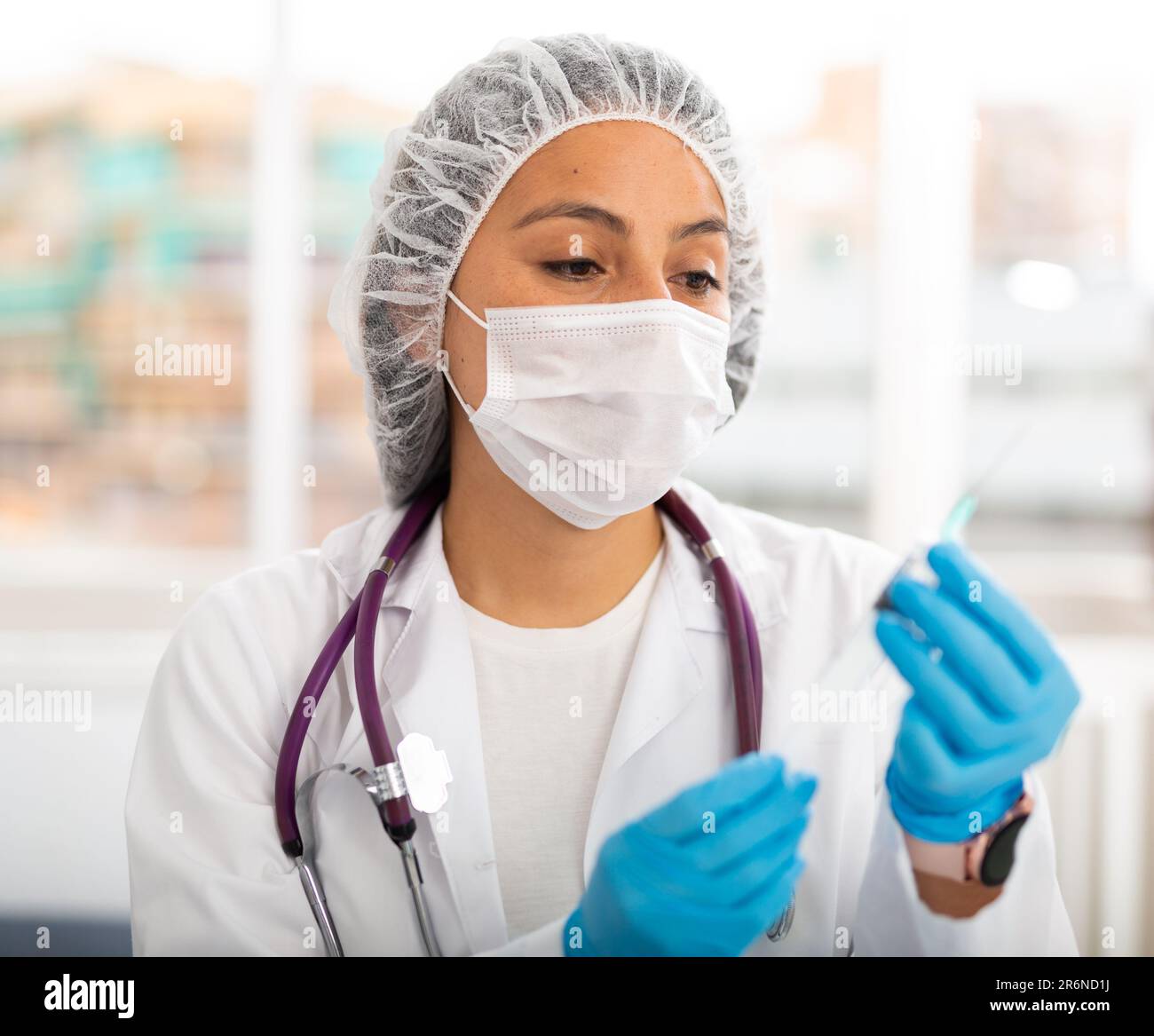 Female health worker prepares a syringe for injection in the treatment ...