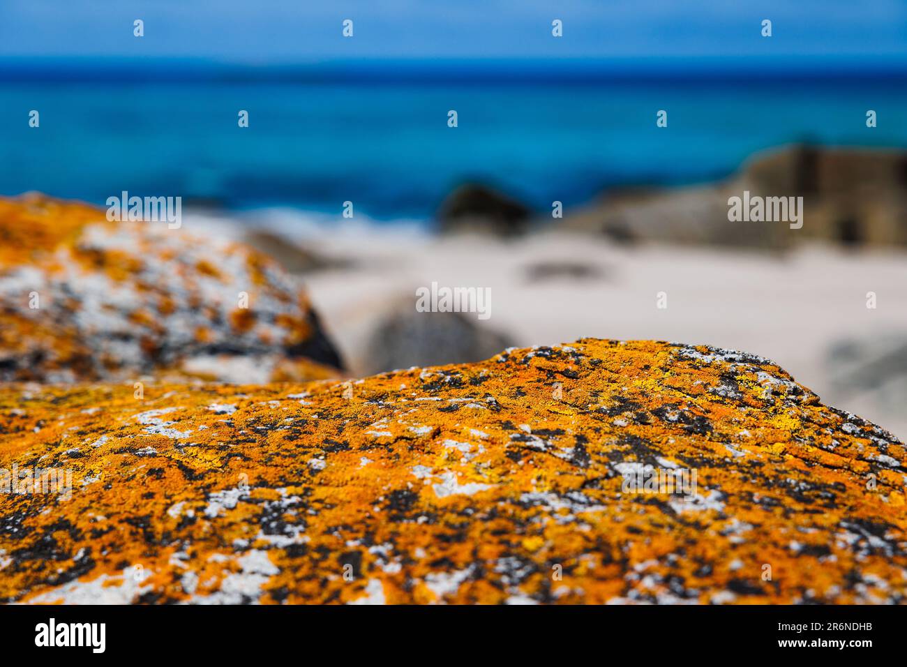 A scenic beach scene featuring a rocky shoreline with blue waters in ...