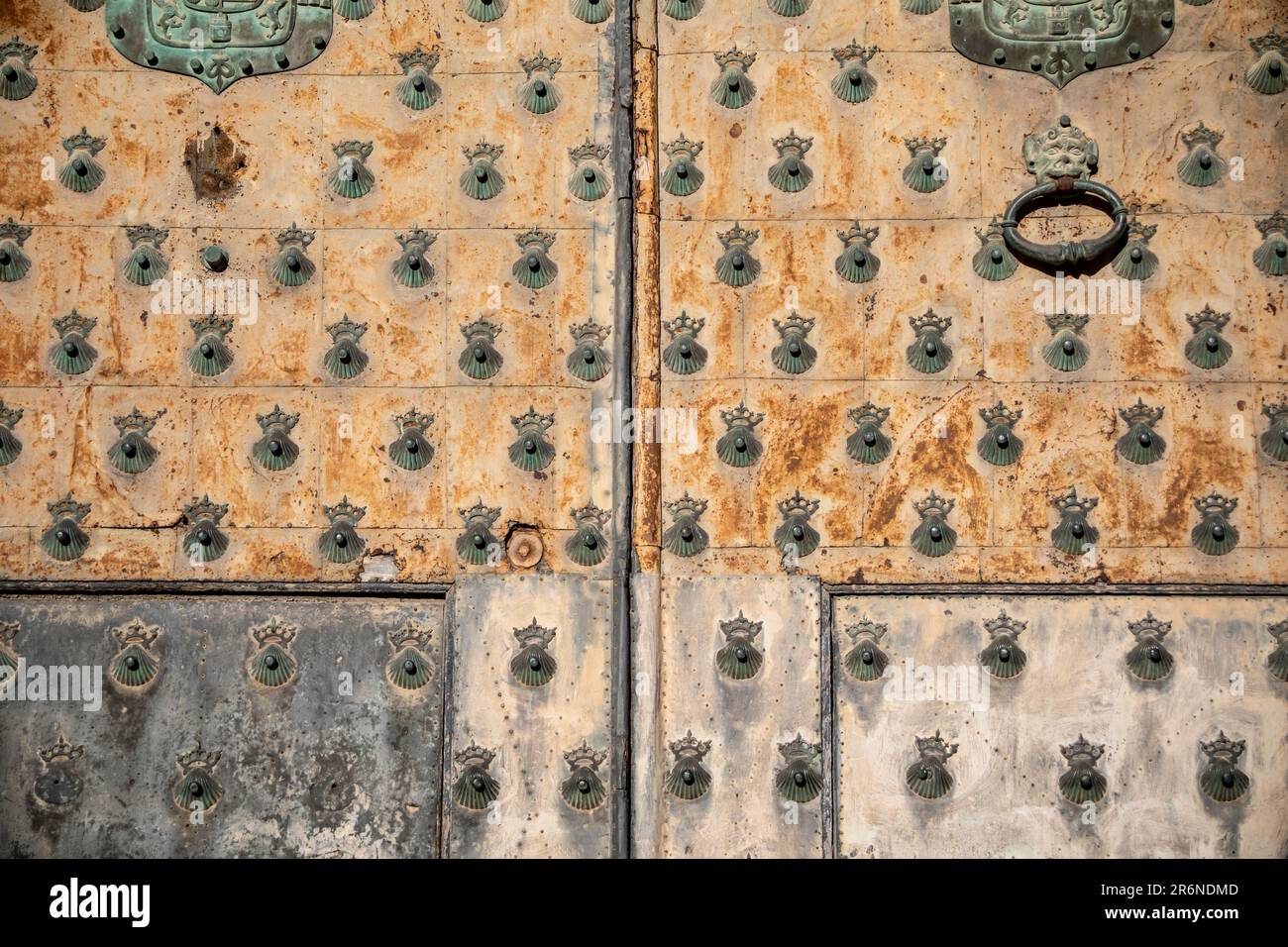 Old and weathered solid wooden door with decorative metal elements that ...