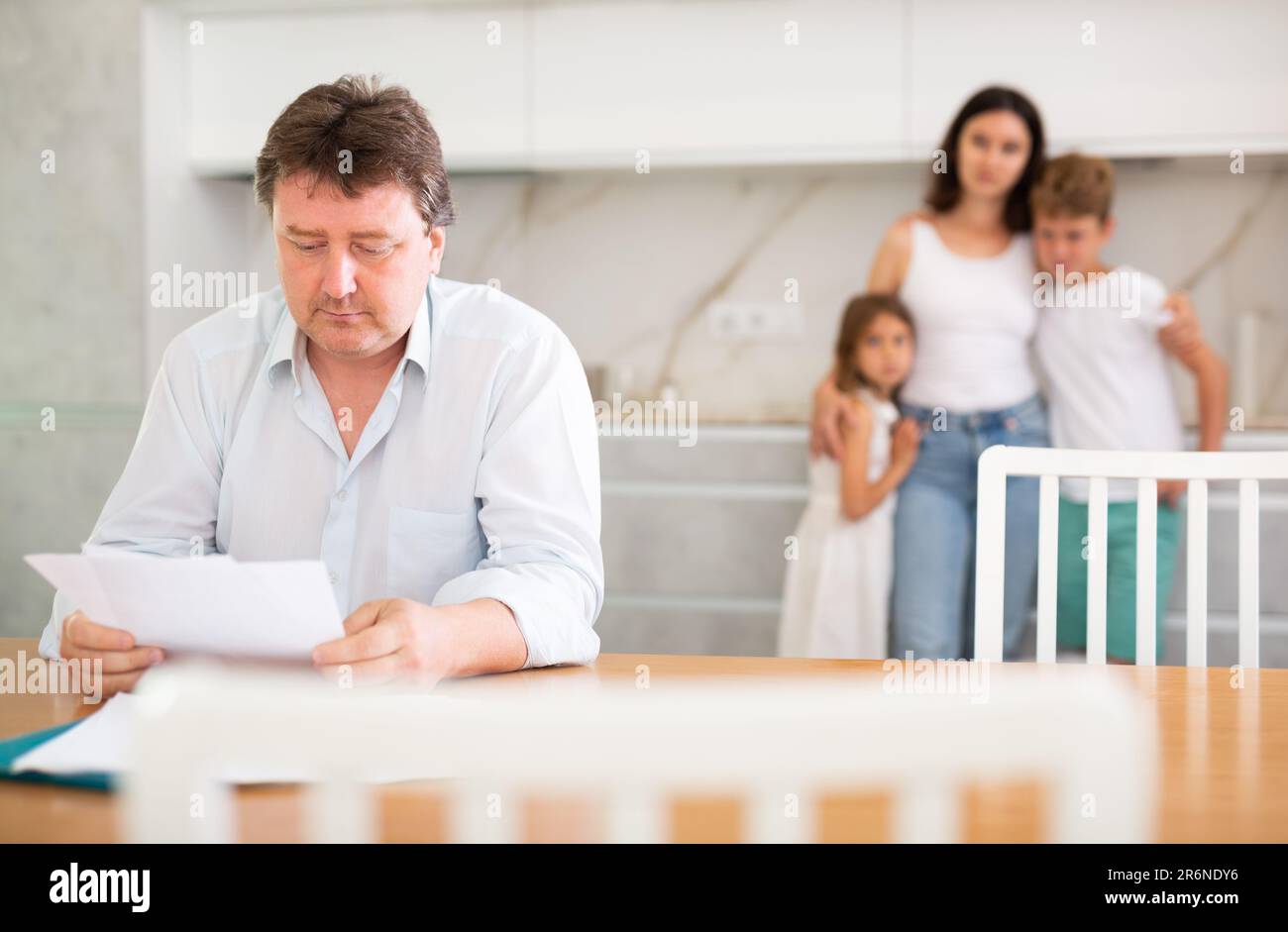 Frightened wife and children stand behind husband and ask about what ...