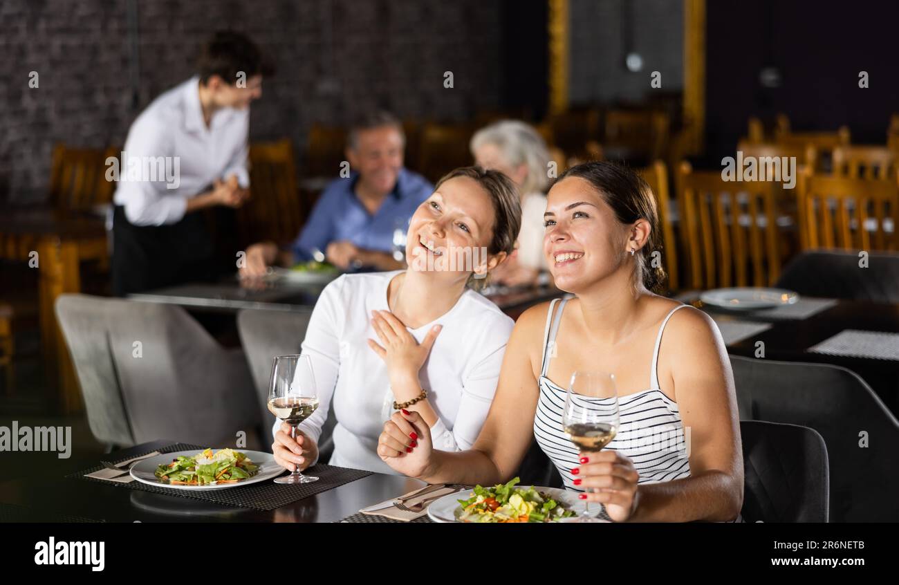 Two young women meeting over dinner in restaurant Stock Photo - Alamy