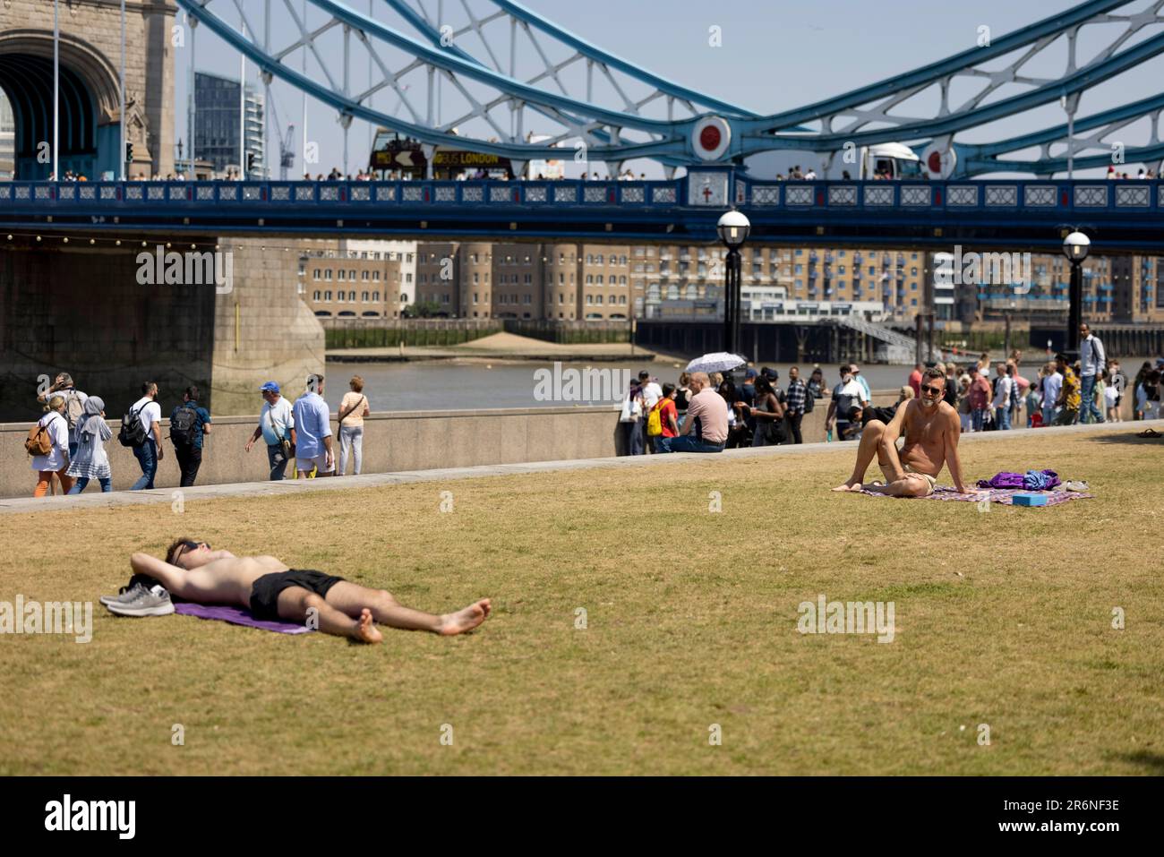 London, UK. 10th June, 2023. People are seen sunbathing at Tower Bridge ...