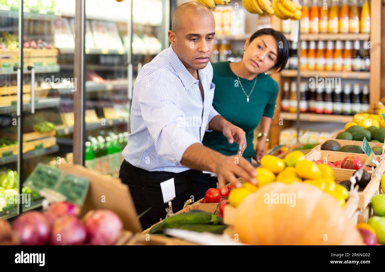 Man and woman picking ripe fruits and vegetables together at ...