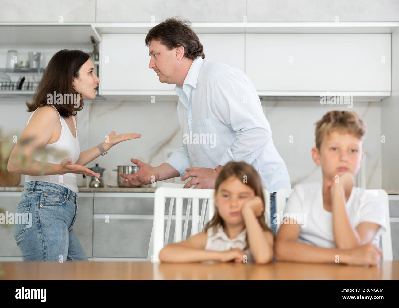 Brother and sister sit at table during quarrel between parents Stock ...