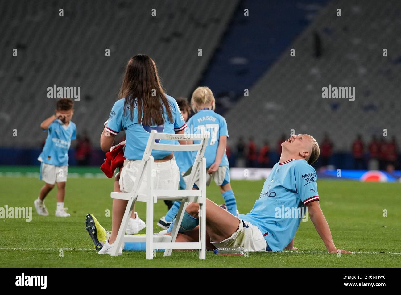 Manchester City's Erling Haaland smiles sitting on the pitch after the ...