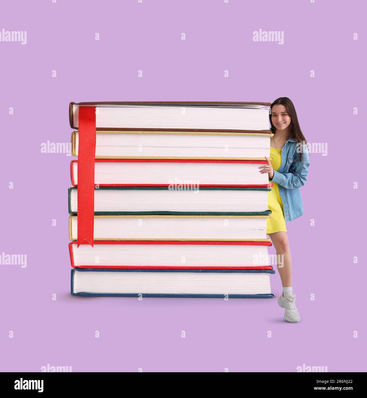 Happy young woman and stack of big books on lilac background Stock ...