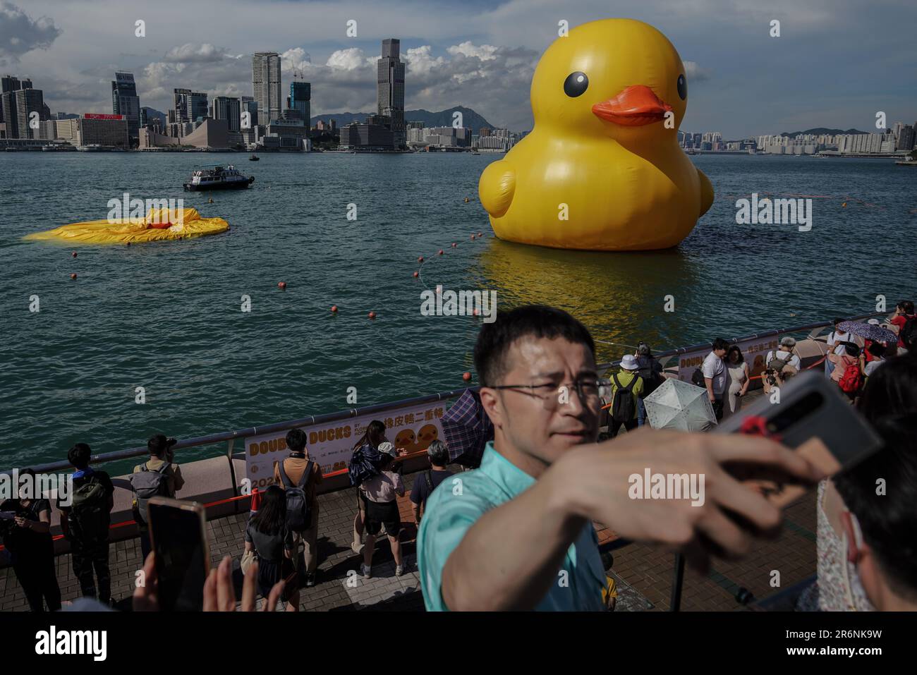 A man takes selfies in front of an enormous inflatable duck which ...
