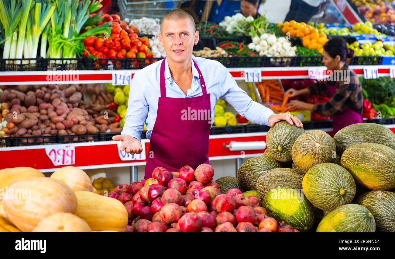 Successful salesman inviting to fruit and vegetable store Stock Photo ...