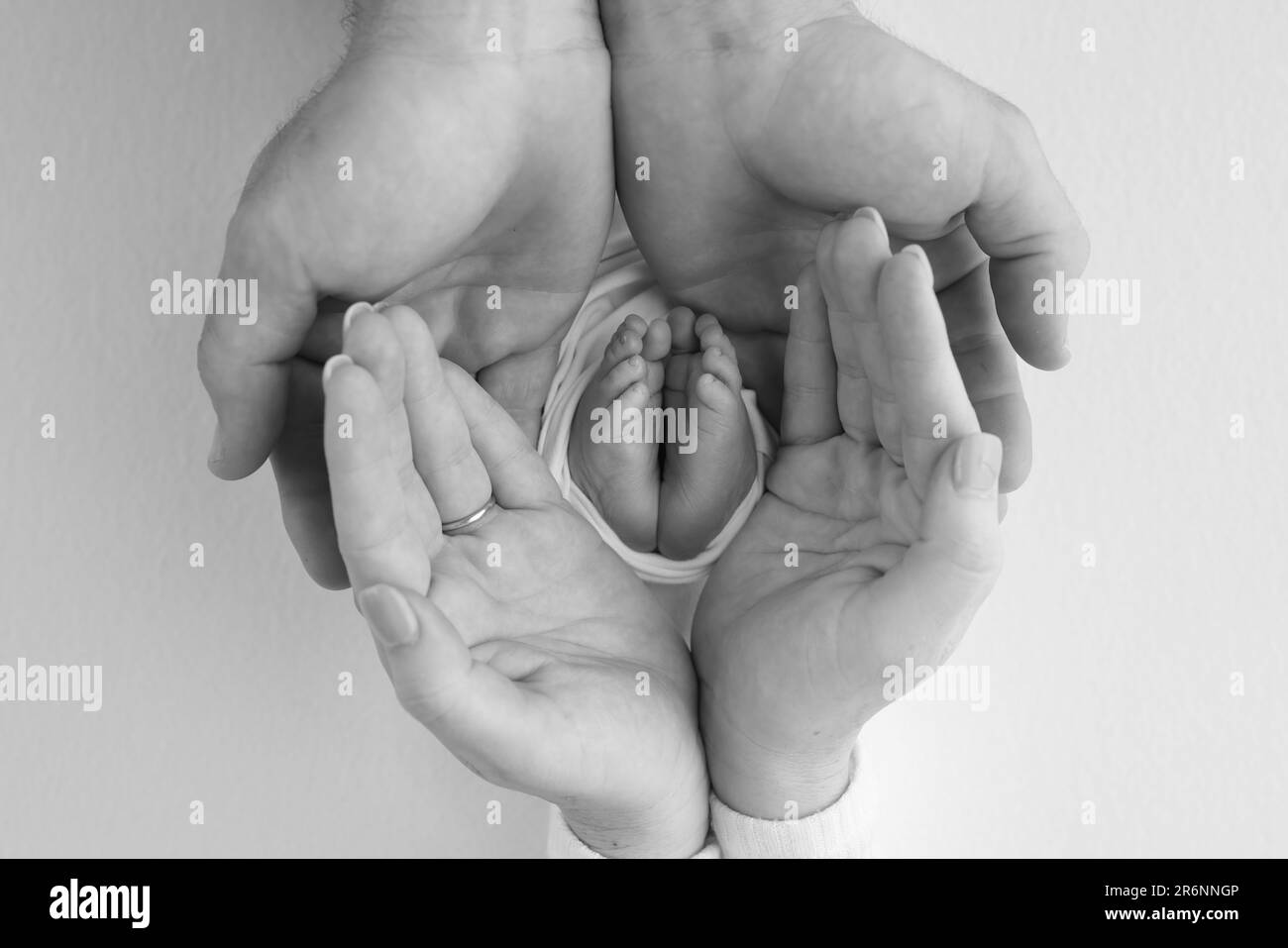 Children's leg in the hands of mother, father, parents. Feet of a tiny ...