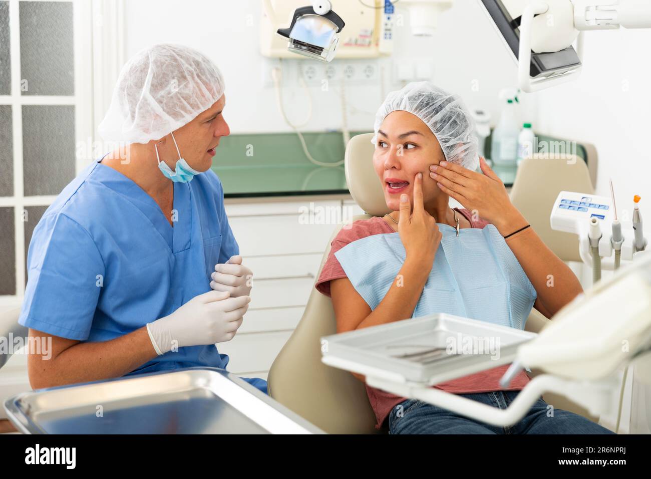 Woman patient showing which side she has a toothache Stock Photo - Alamy