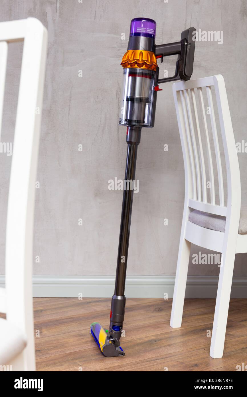 Handheld vacuum cleaner leaned against chair in room Stock Photo - Alamy