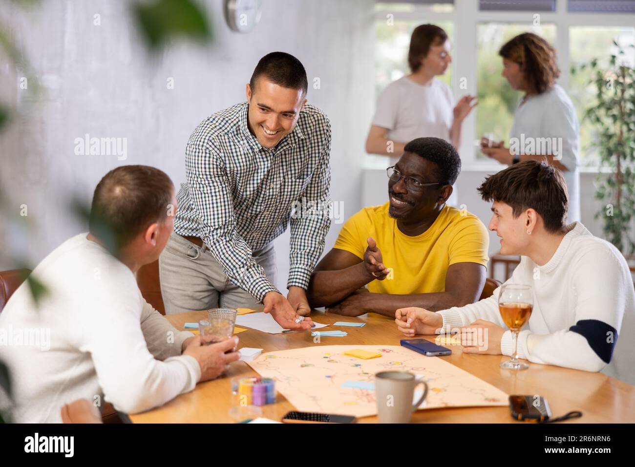 Positive man playing board game with male friends Stock Photo - Alamy
