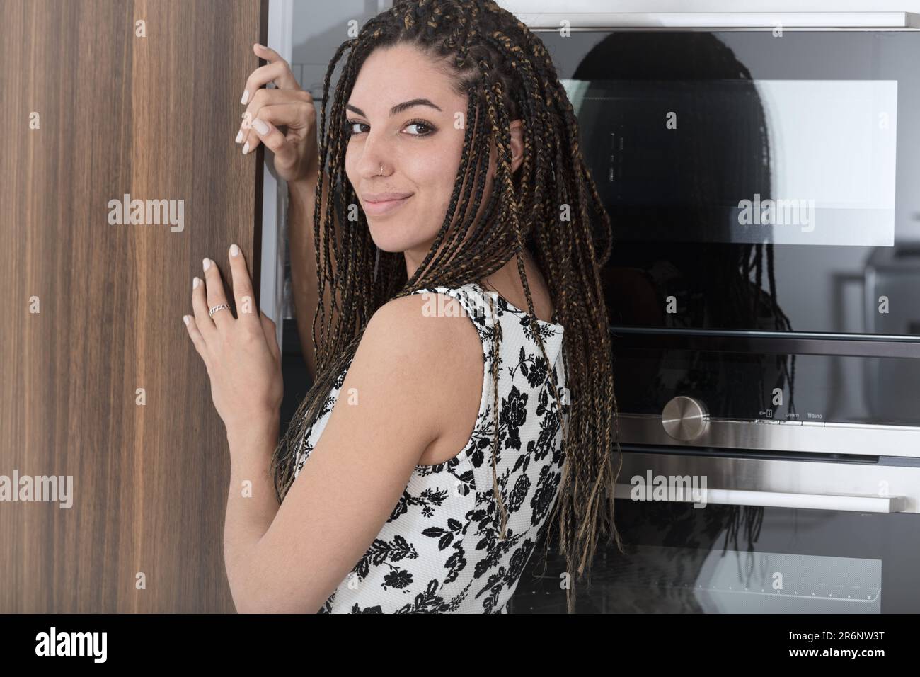 Young woman with box braids and a floral dress proudly poses in her new ...