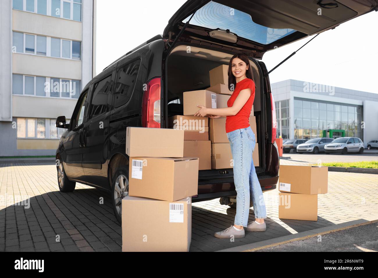 Courier taking parcel from delivery van outdoors Stock Photo - Alamy