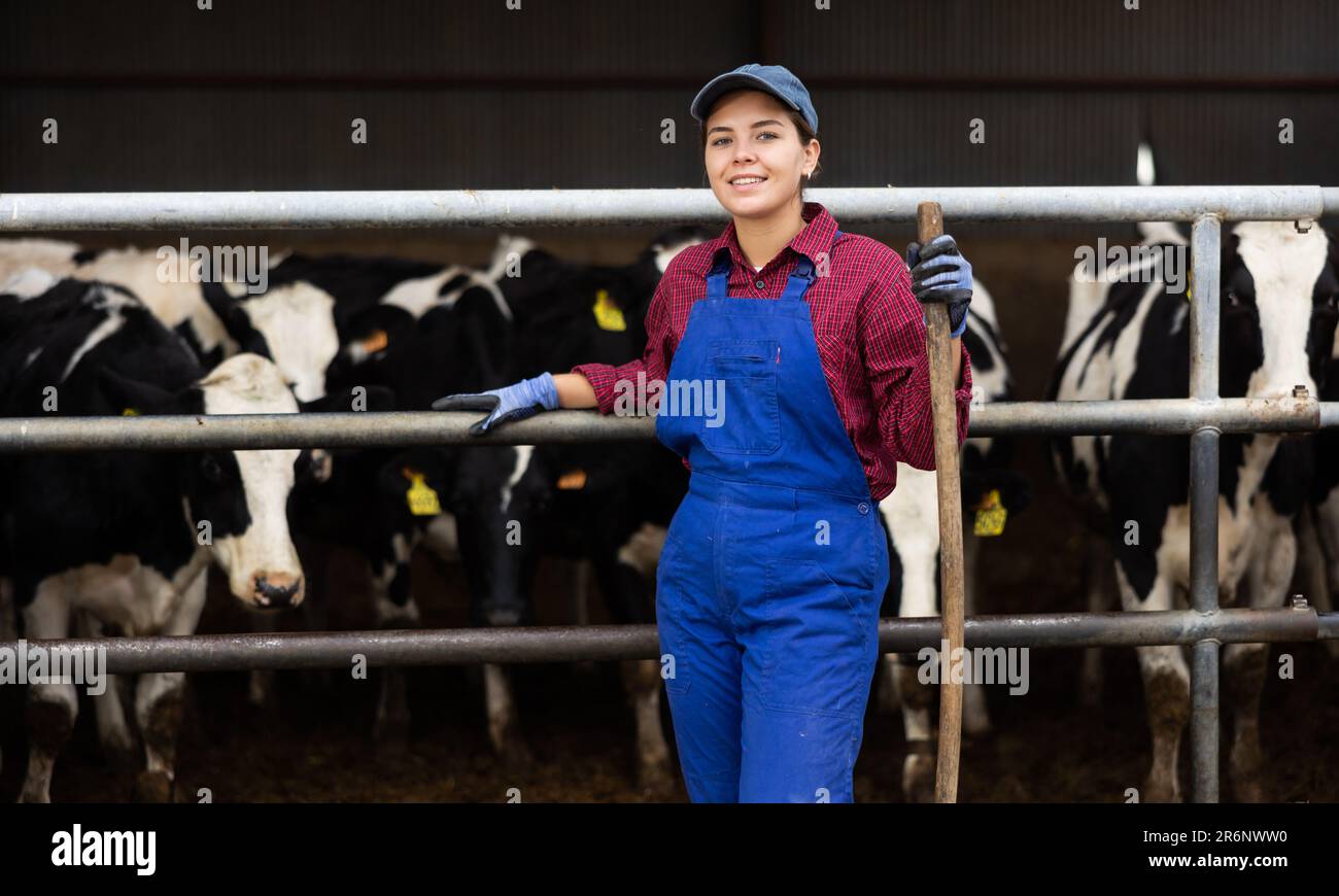 Portrait of positive female farm worker in cowshed Stock Photo - Alamy