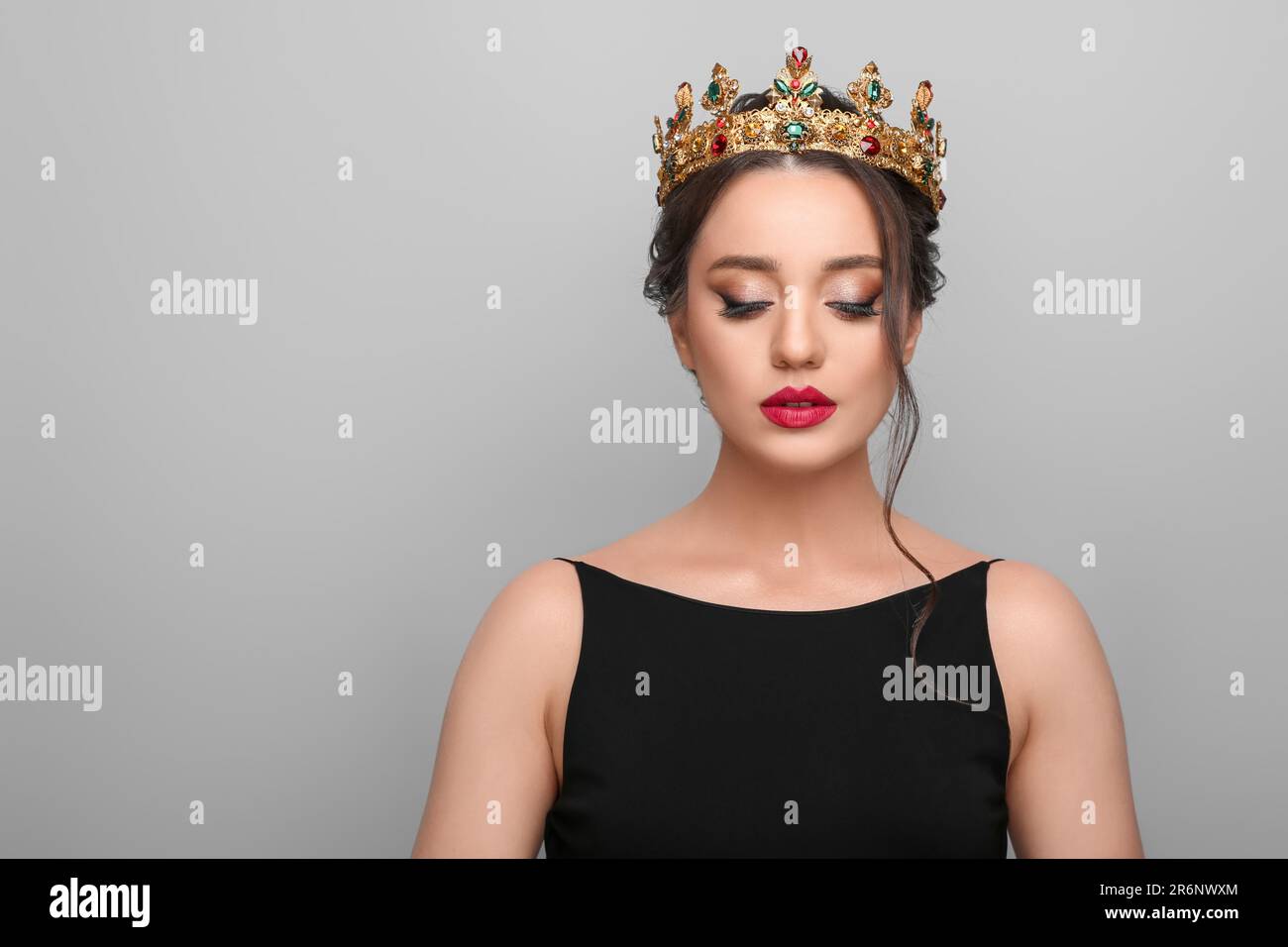 Beautiful young woman wearing luxurious crown on light grey background, space for text Stock ...