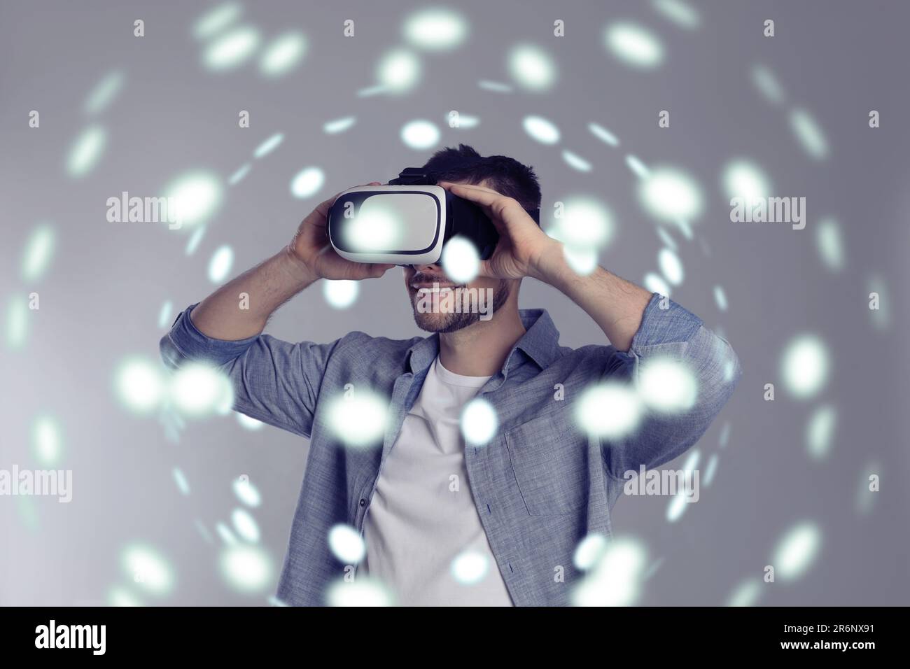 Innovation idea. Man using VR headset. Lights around him symbolizing ...