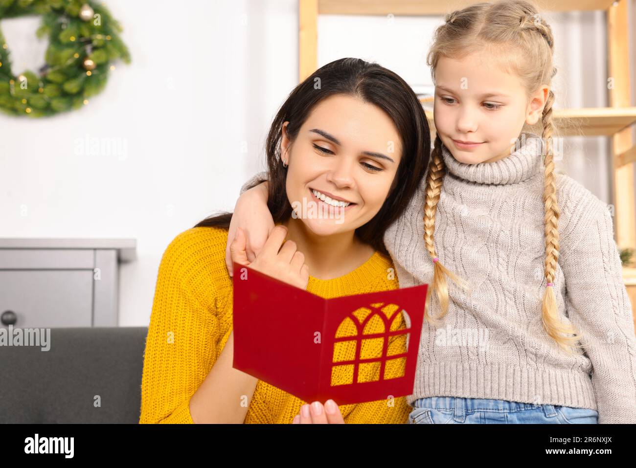 Happy woman receiving greeting card from her daughter at home Stock ...