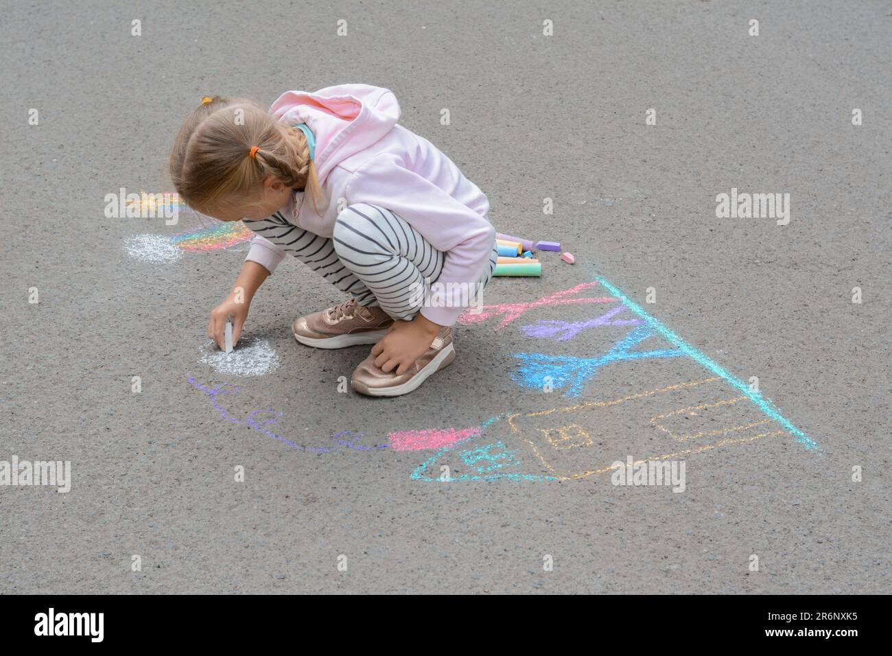 Little child drawing happy family with chalk on asphalt Stock Photo - Alamy