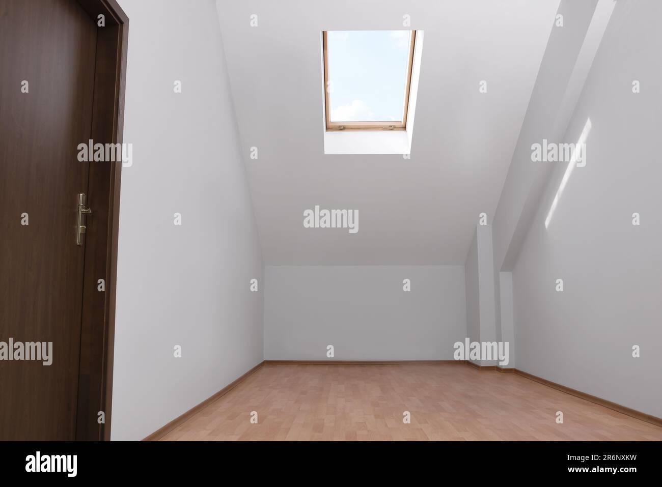 Light spacious attic room with window on slanted ceiling Stock Photo ...