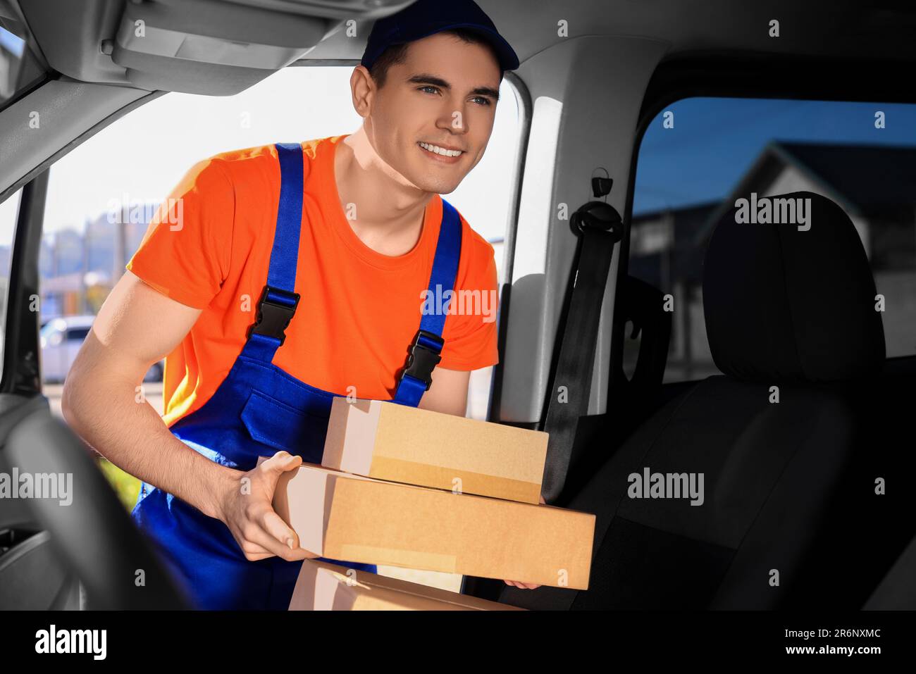 Courier taking parcels from car. Delivery service Stock Photo - Alamy