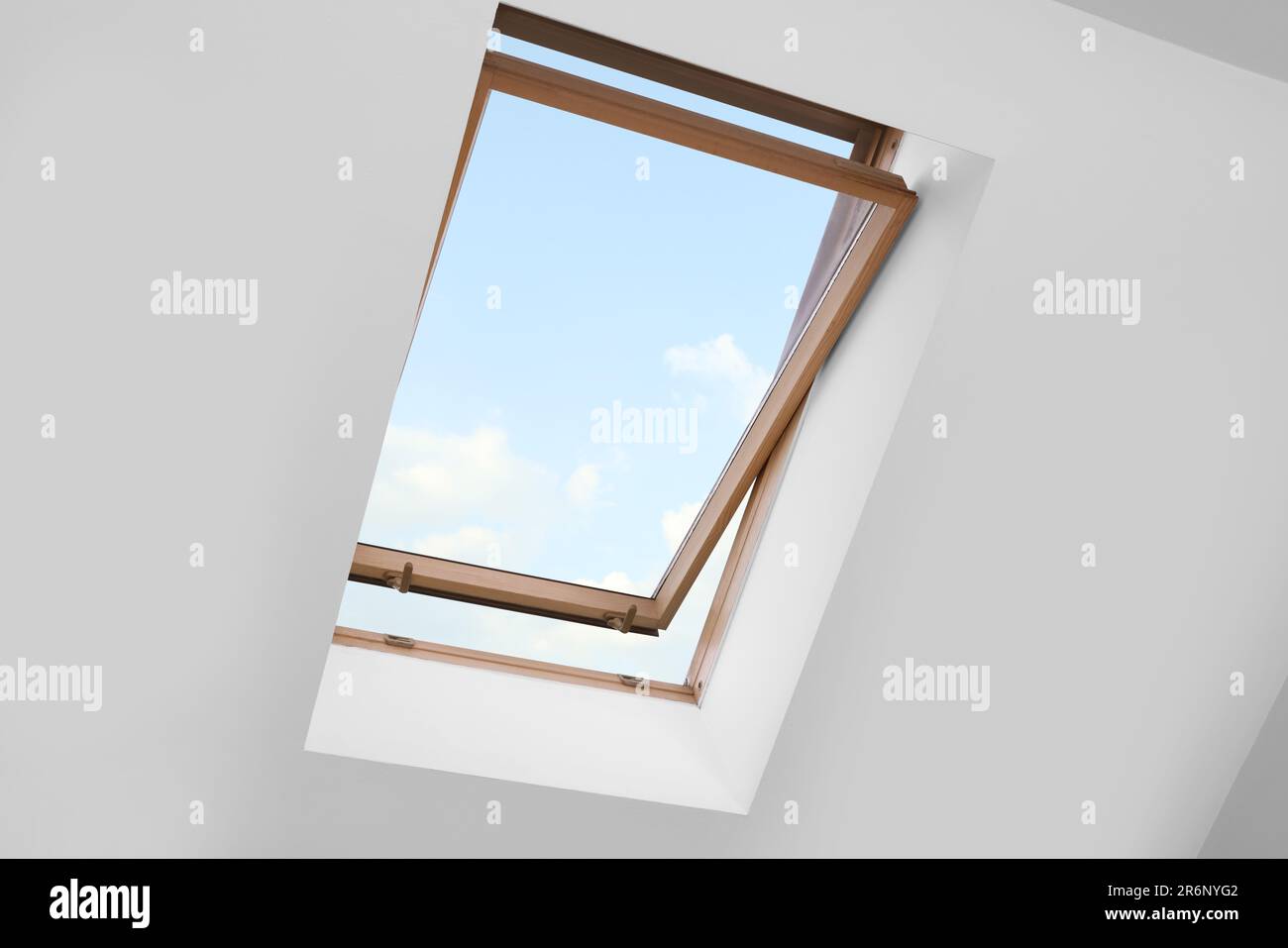 Skylight roof window and lamps on slanted ceiling in attic room, low ...