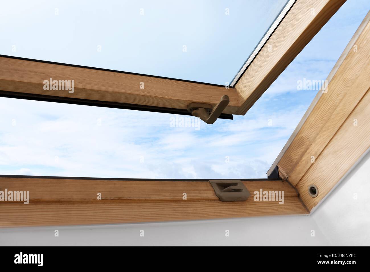 Beautiful view of cloudscape from open skylight roof window on slanted ceiling. Attic room Stock ...