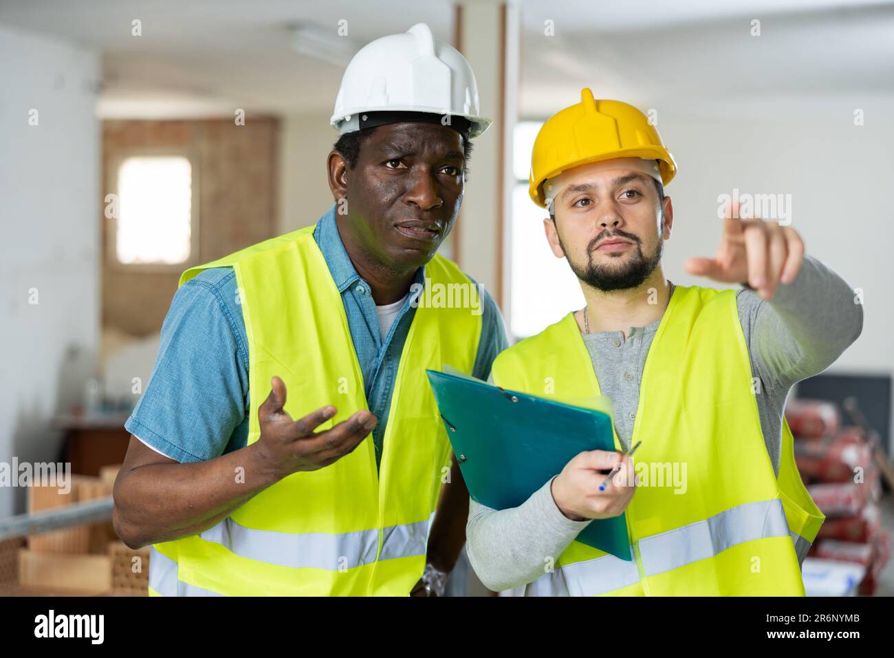 Two builders discussing working plan in apartment during repair works ...