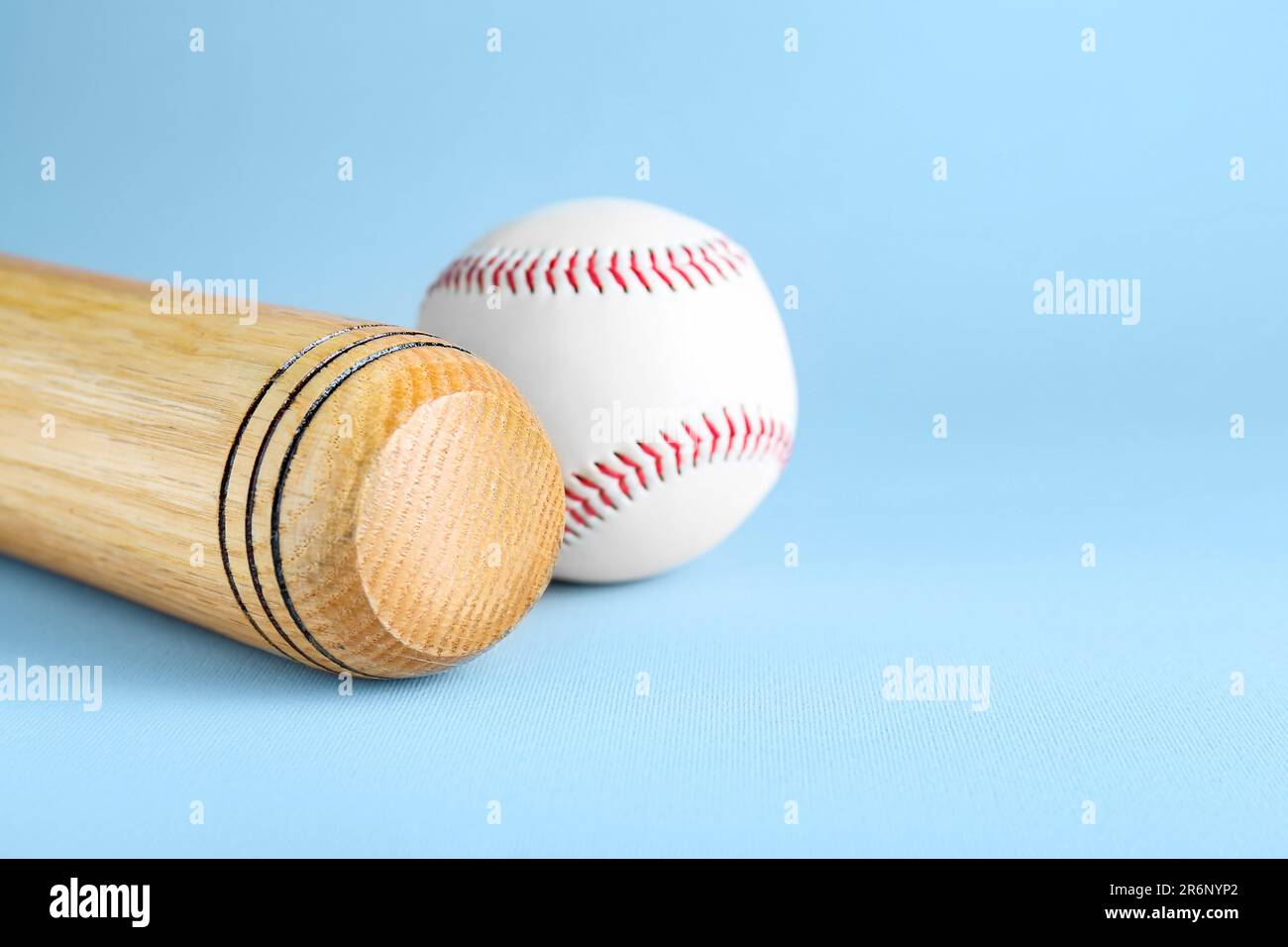 Wooden baseball bat and ball on light grey background, space for text ...