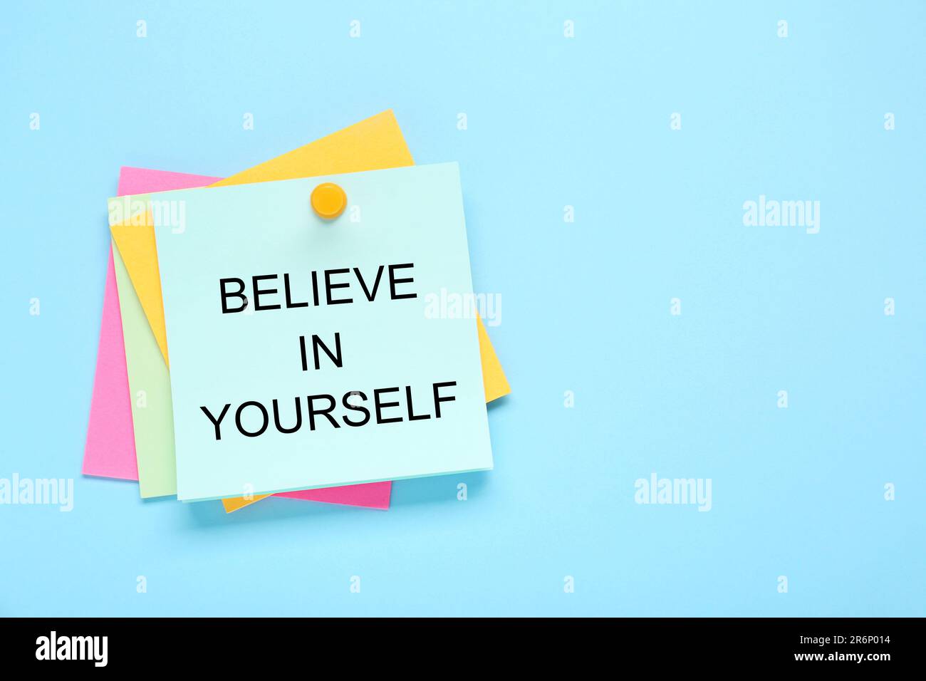 Notes with phrase Believe In Yourself on light blue background, top ...