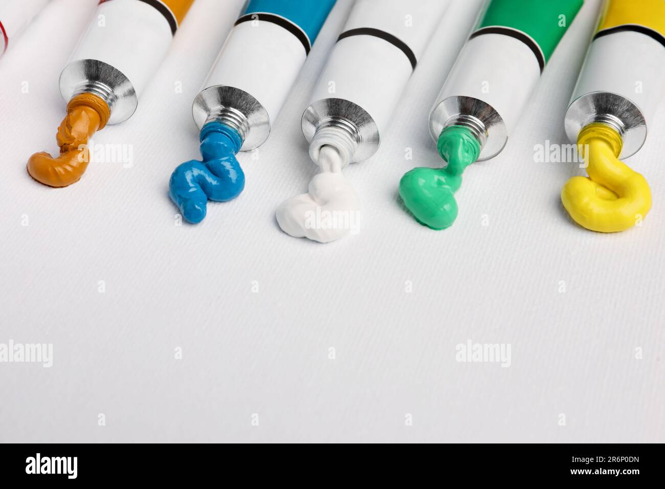 Tubes with oil paints on white canvas, closeup. Space for text Stock ...