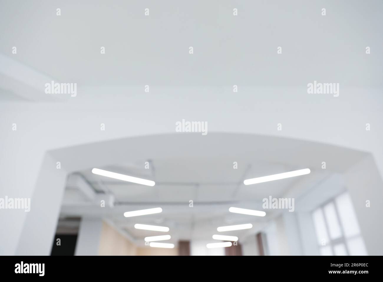 Blurred view of white ceiling with modern lighting in room Stock Photo ...