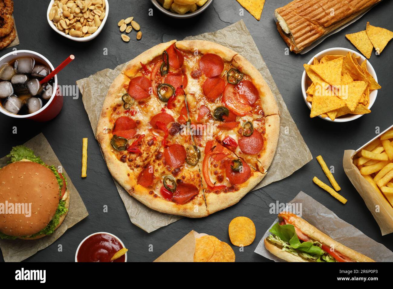 Pizza, burger and other fast food on black table, flat lay Stock Photo ...