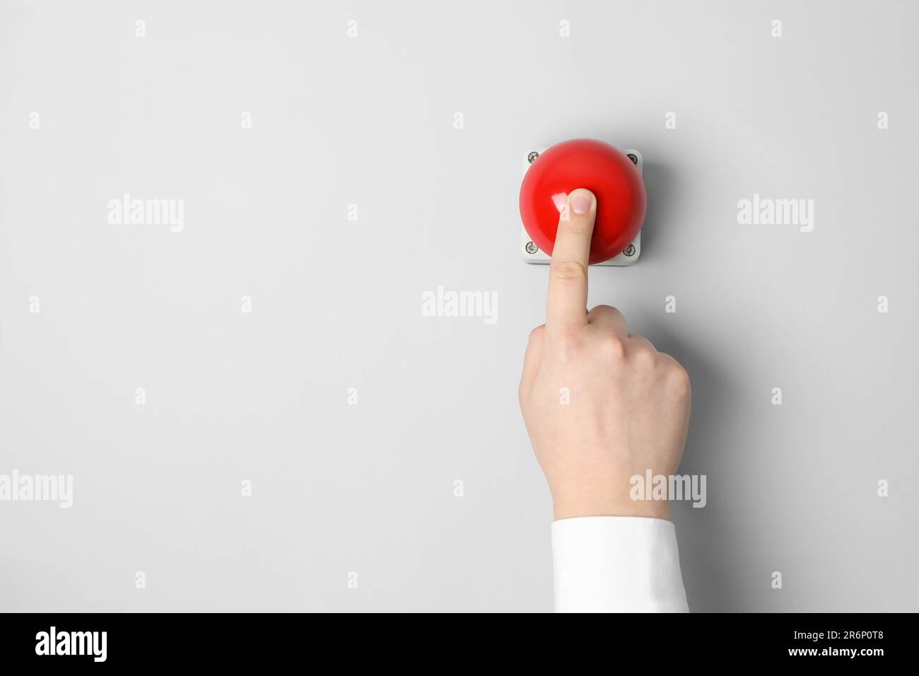 Man pressing red button of nuclear weapon on white background, top view ...