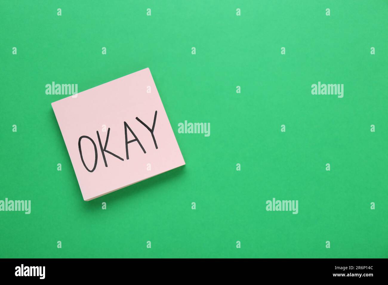 Note with word Okay on green background, top view. Space for text Stock ...