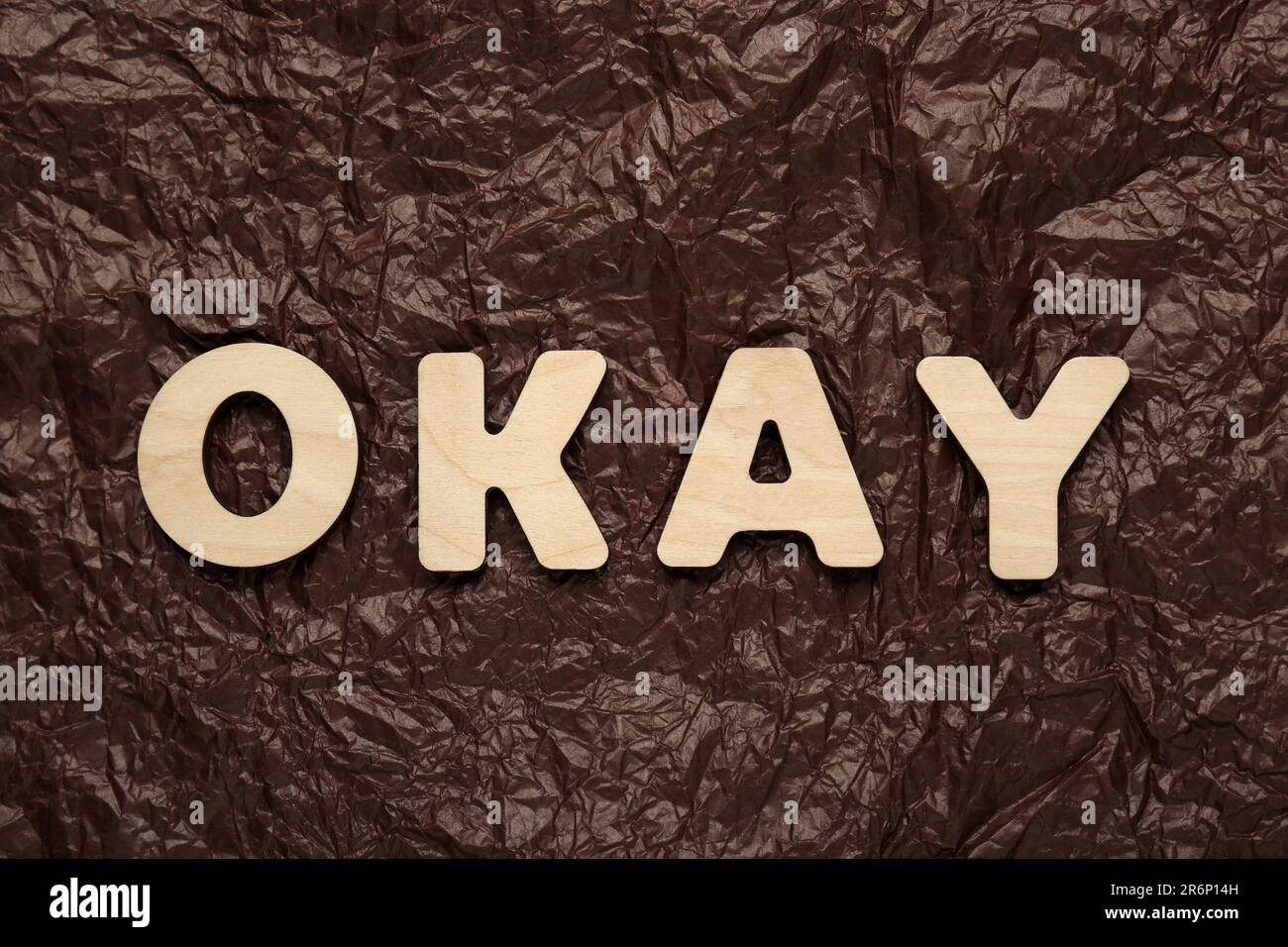 Word Okay made of wooden letters on crumpled paper, top view Stock ...