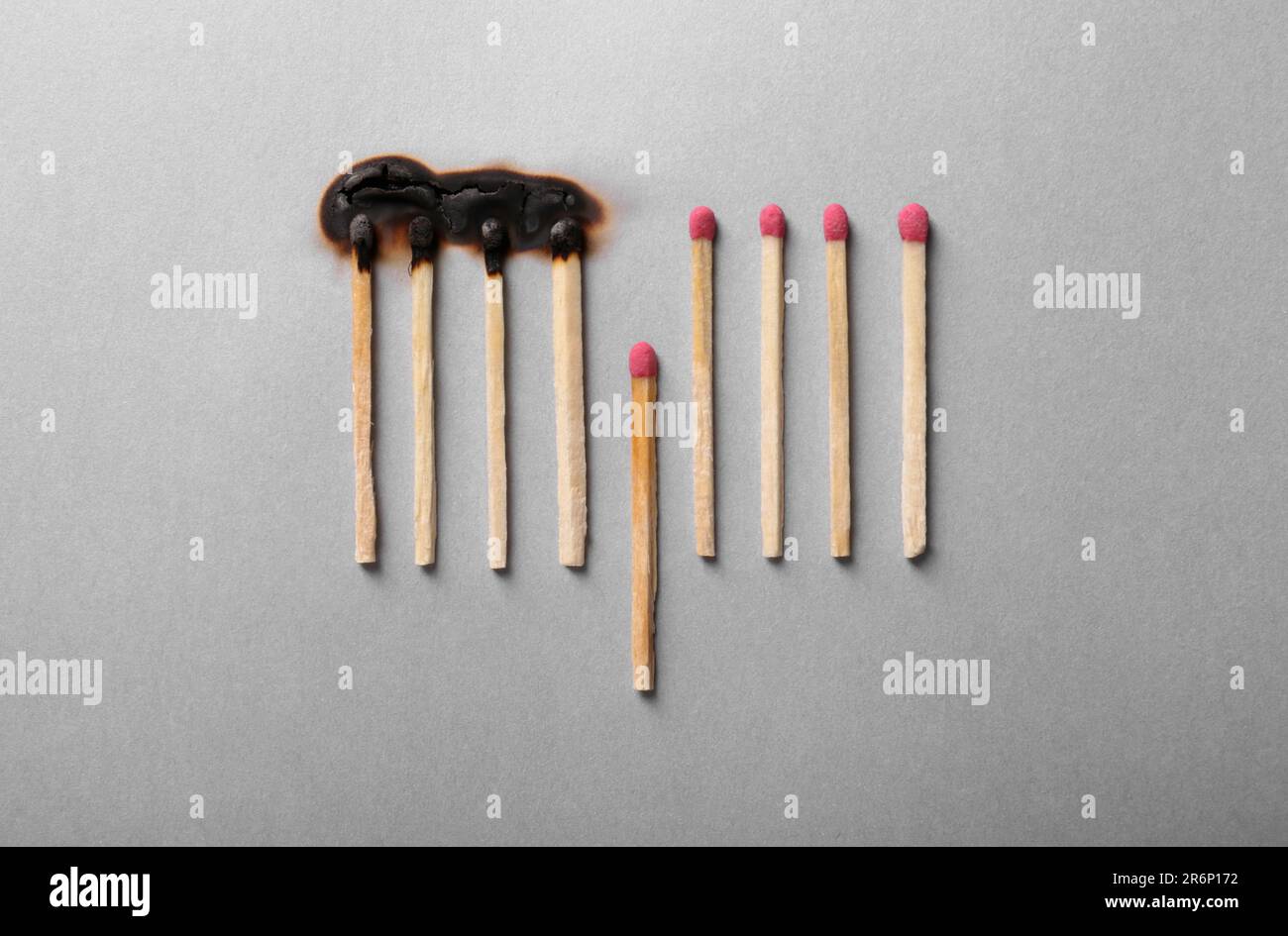 Burnt and whole matches on light grey background, flat lay. Stop ...