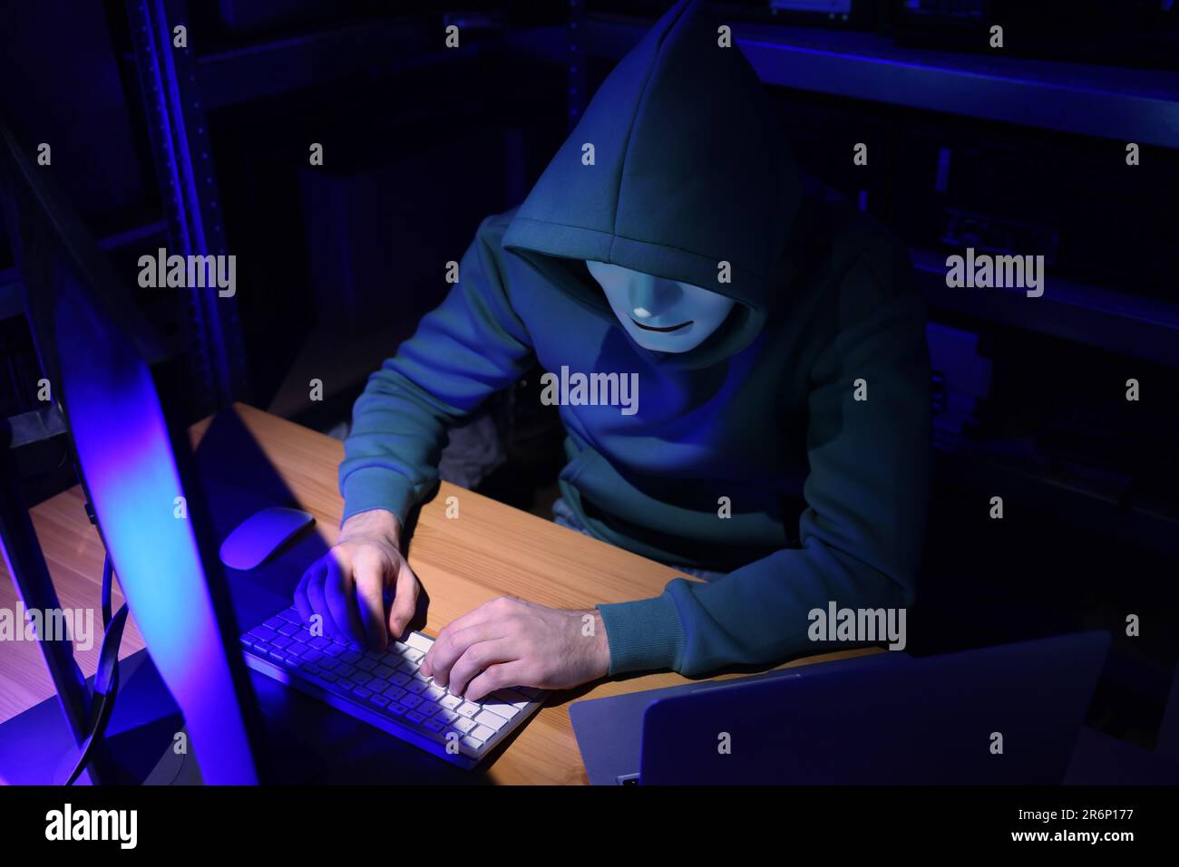 Hacker in mask working with computers in dark room. Cyber attack Stock Photo - Alamy