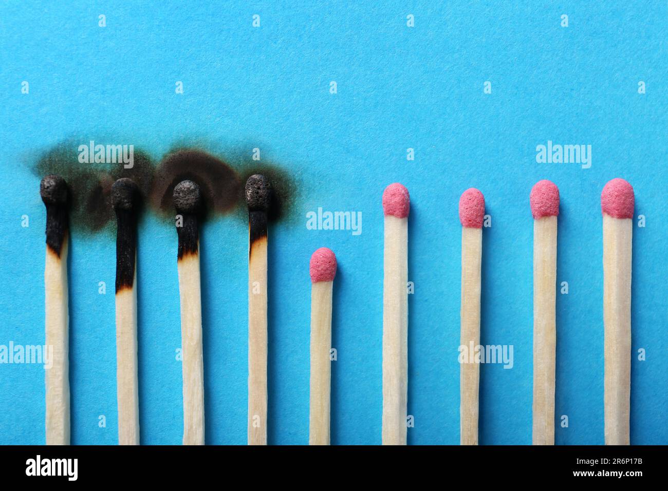 Burnt and whole matches on light blue background, closeup. Stop ...