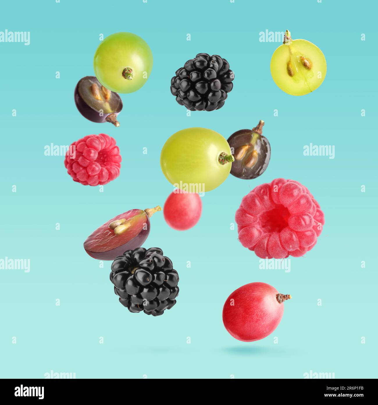 Different fresh berries falling on light blue background Stock Photo ...